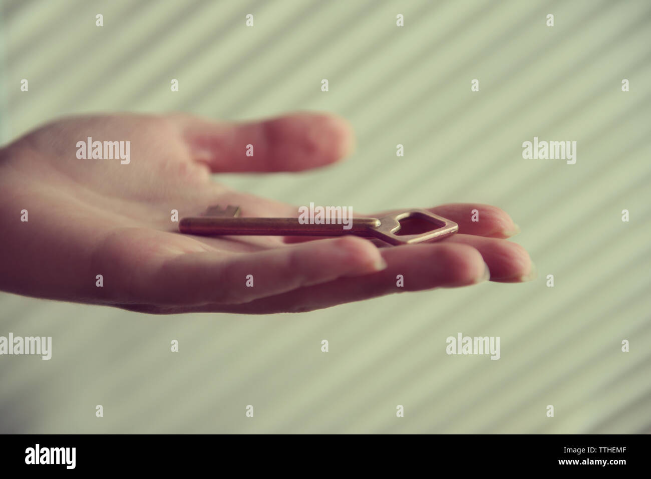 Female hand holding old key closeup Stock Photo - Alamy