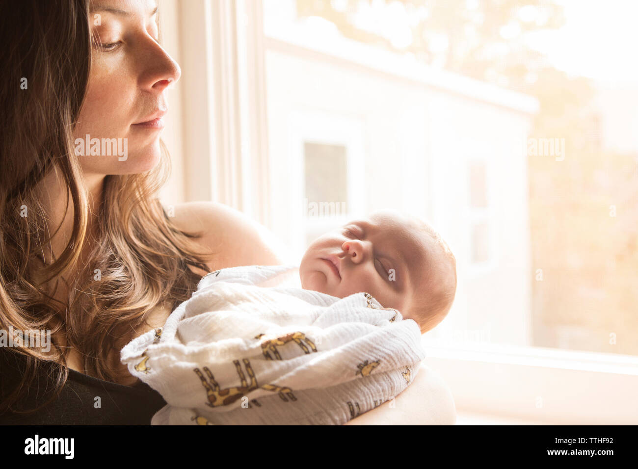 Mother holding child window hi-res stock photography and images - Alamy