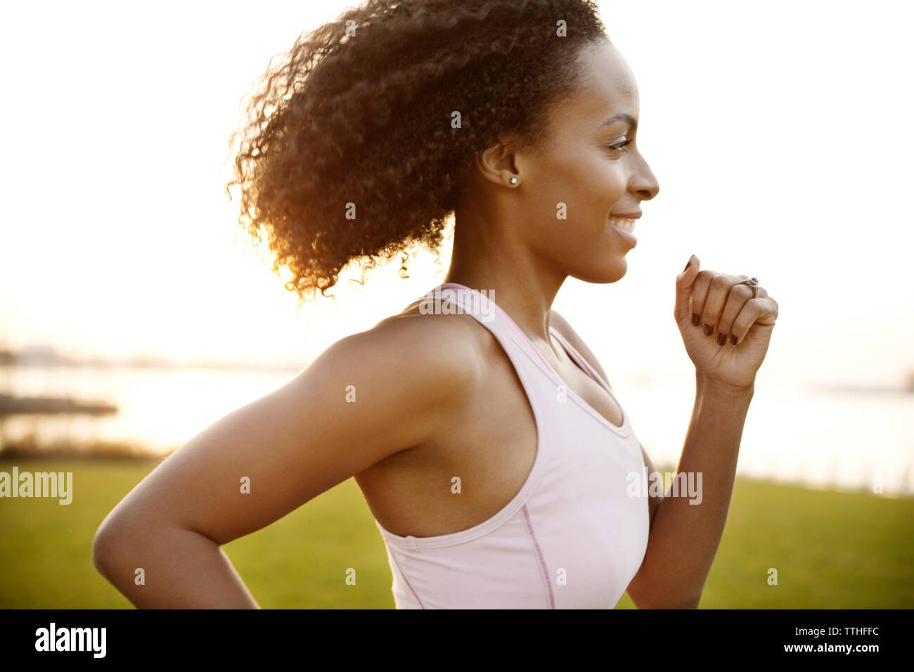 Side view of determined woman jogging in park Stock Photo - Alamy