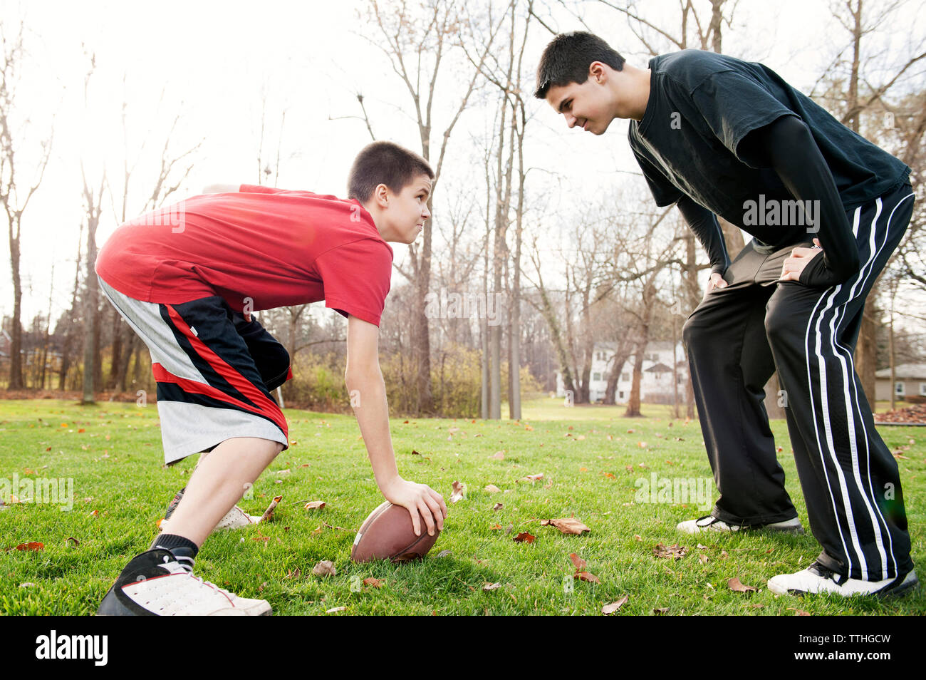 Brothers playing American football on grassy field Stock Photo - Alamy