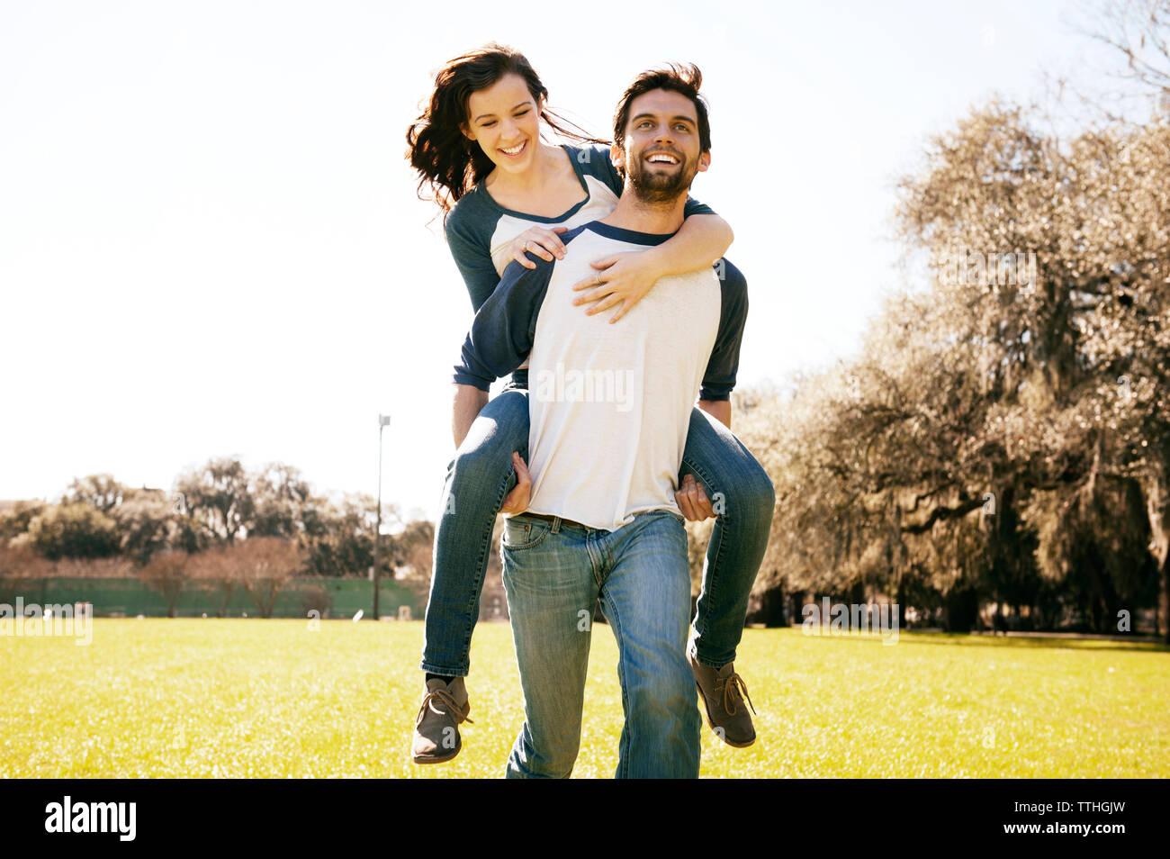 Man giving piggyback ride to woman at park Stock Photo - Alamy