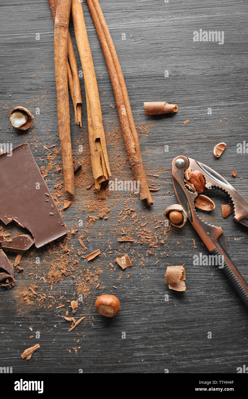 Pieces of chocolate with hazelnuts, cracker and cinnamon on black ...