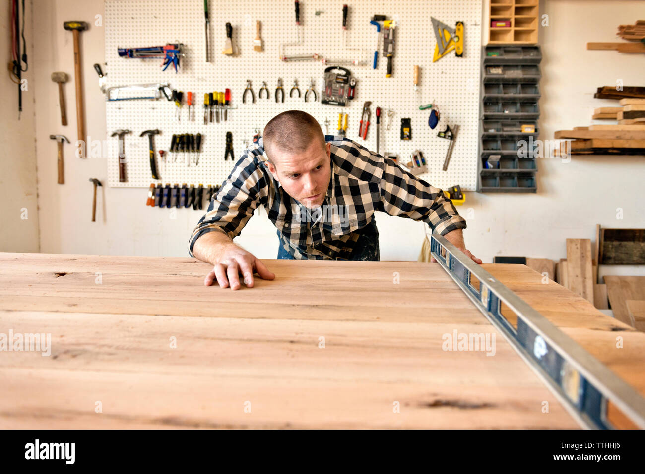 Carpenter checking wood with equipment in workshop Stock Photo - Alamy