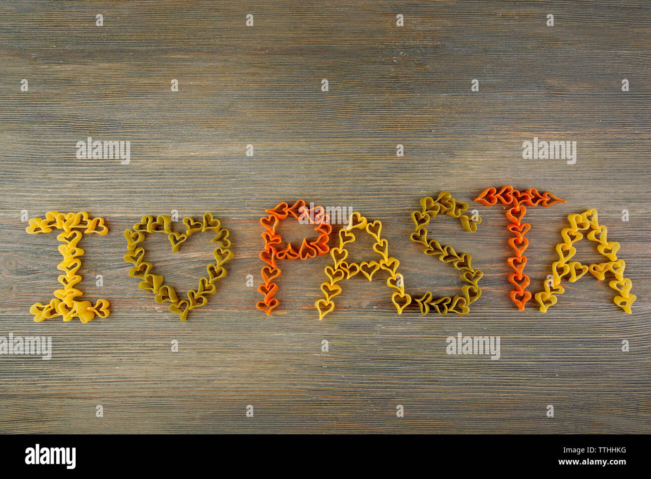 I love pasta inscription made with varicolored heart shaped on wooden ...