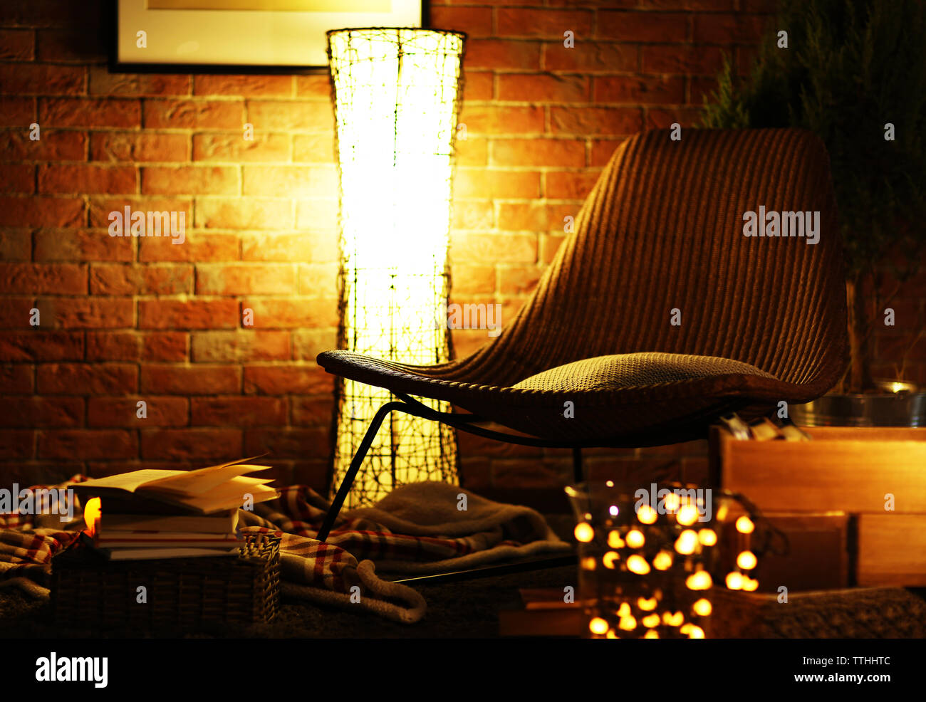 Cozy design interior with chair and light of lamp against brick wall ...