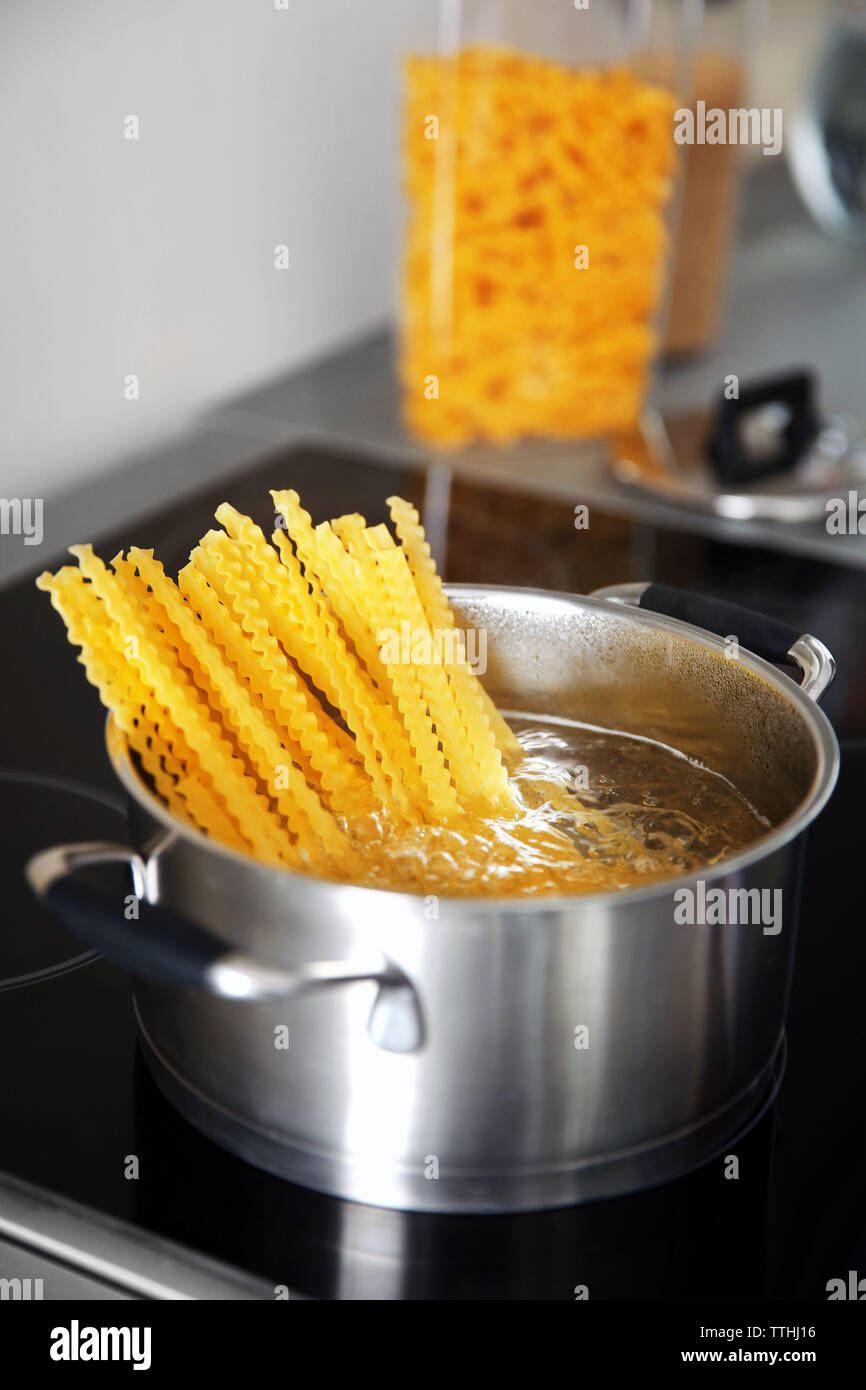 Boiling pasta in pan on electric stove in the kitchen Stock Photo - Alamy