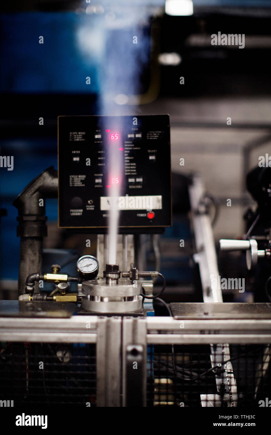 Smoke emitting from machinery in factory Stock Photo - Alamy
