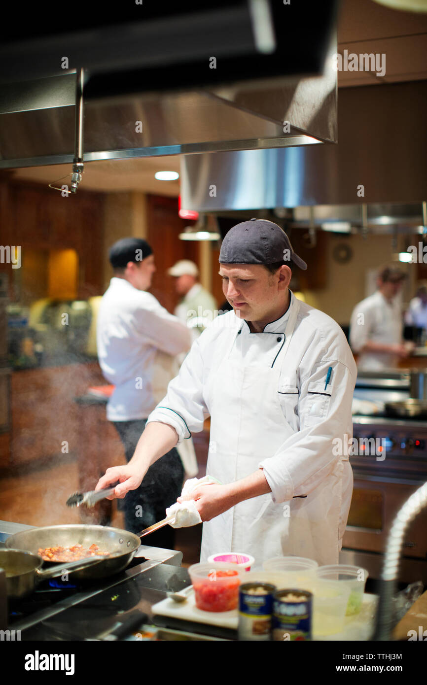 Chef cooking food in commercial kitchen Stock Photo - Alamy