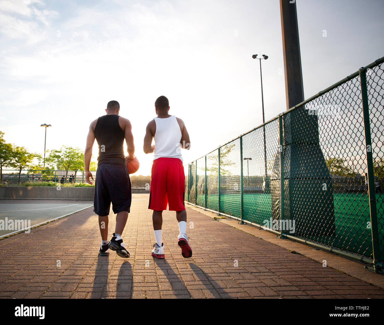 Rear view of basketball players walking in court Stock Photo - Alamy