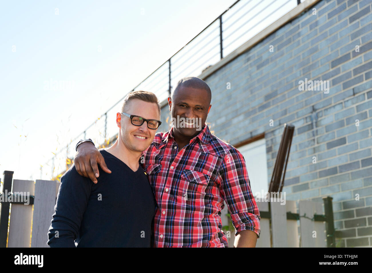 Portrait of happy man standing arm around with boyfriend against ...