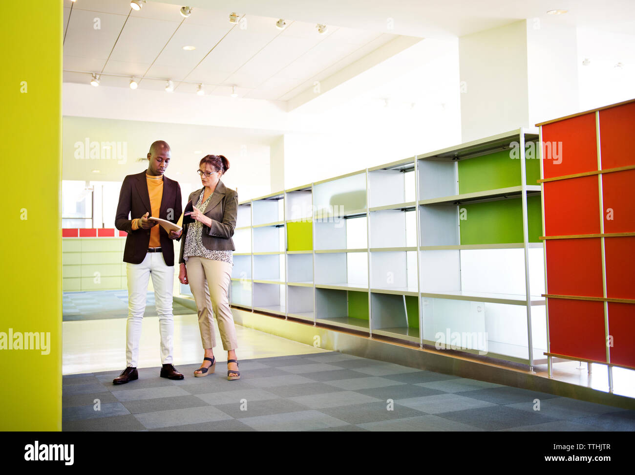 business colleagues having discussion while standing in creative office ...