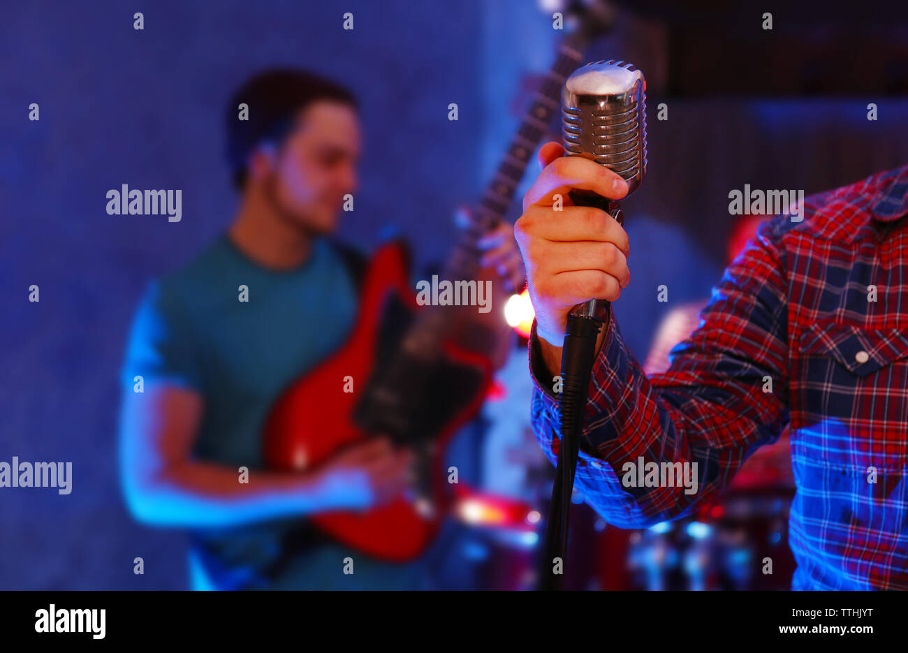 Male hand holding microphone on stage Stock Photo - Alamy