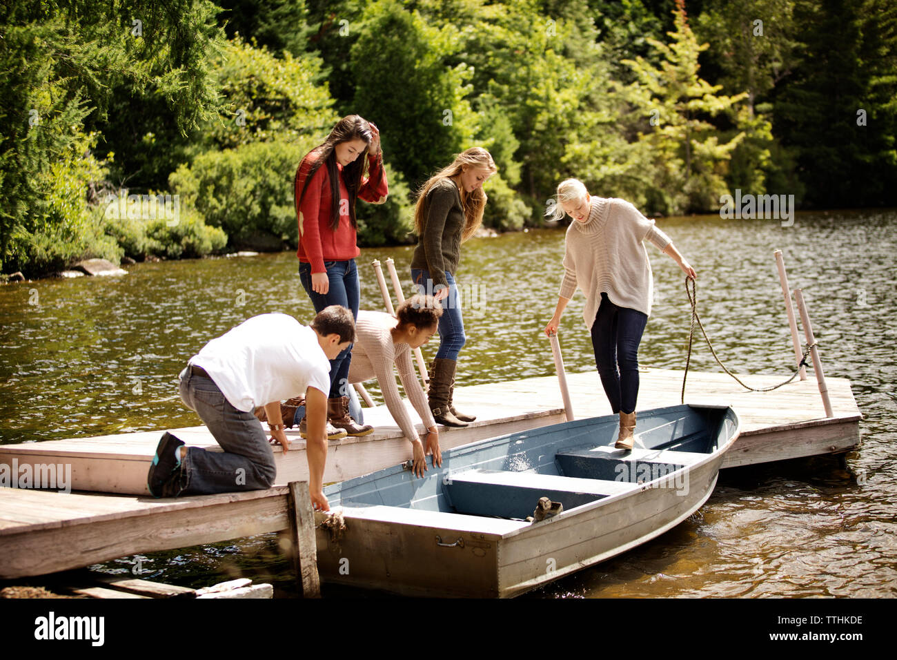 Friends on pier by boat at lake Stock Photo - Alamy