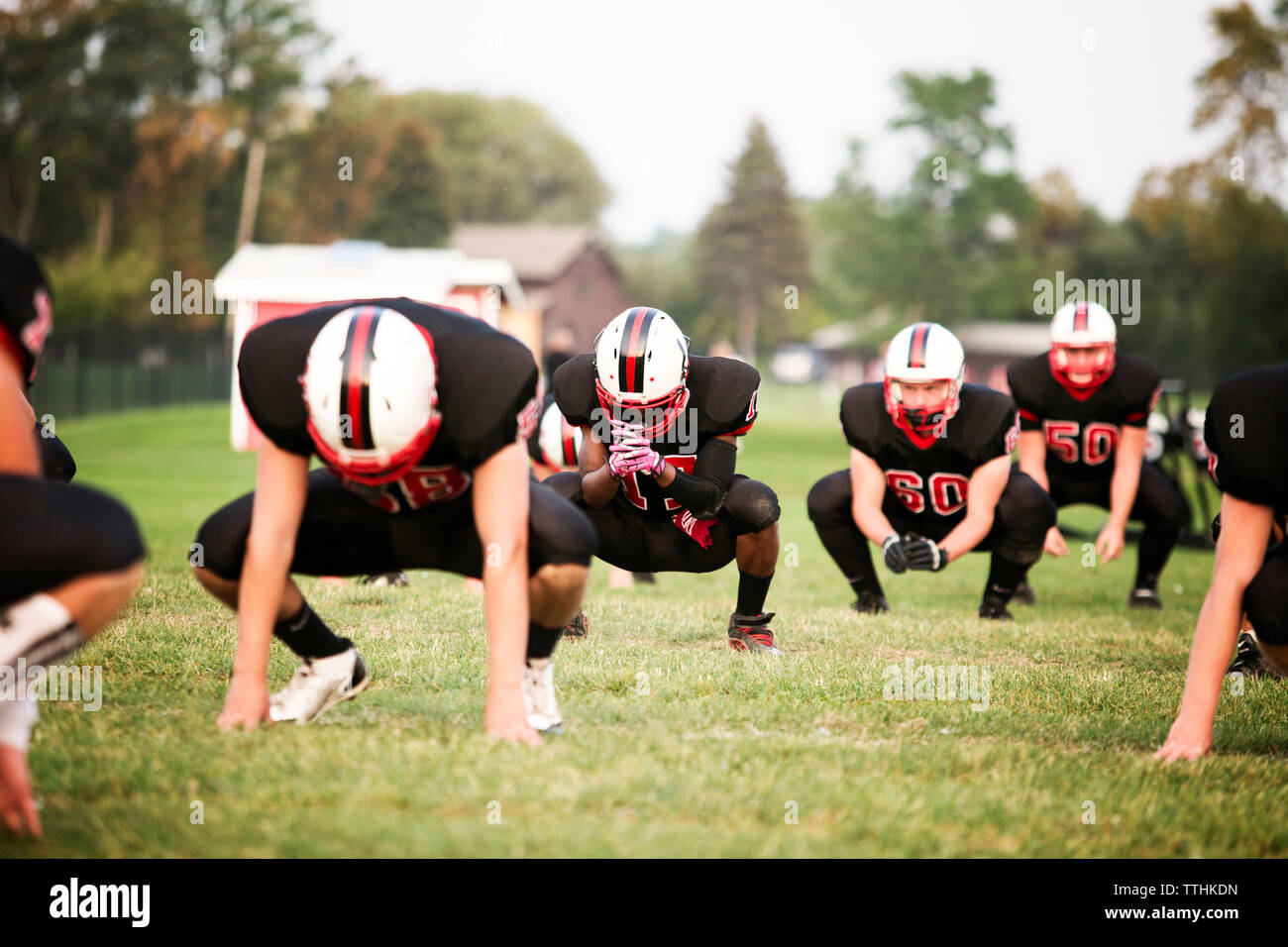 American football players crouching on grassy field Stock Photo - Alamy