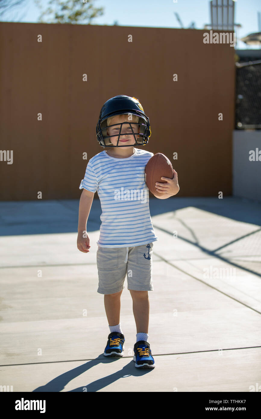 Portrait of happy boy holding football Stock Photo - Alamy