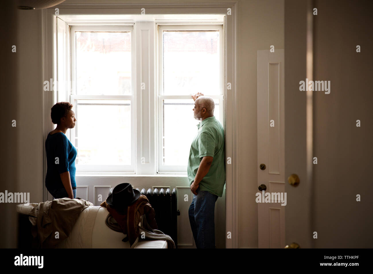 Father and daughter standing by window at home Stock Photo - Alamy