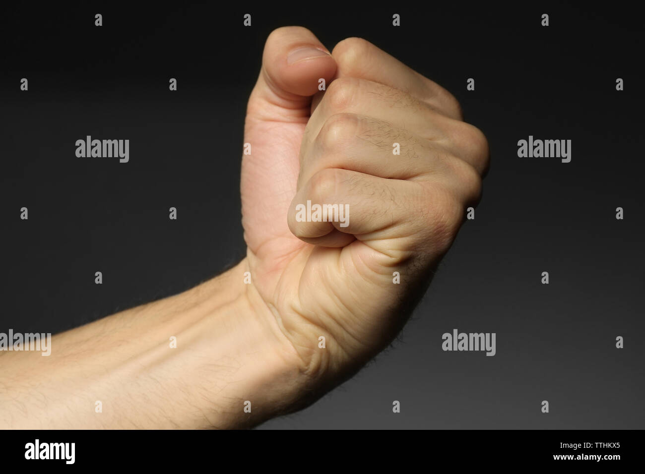 Male fist on grey background Stock Photo - Alamy