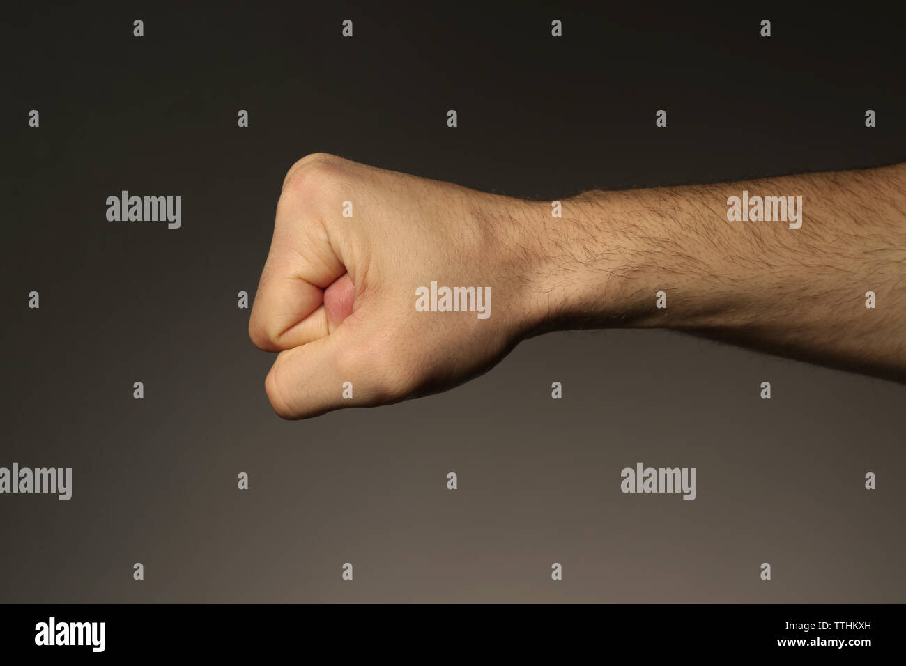 Male fist on grey background Stock Photo - Alamy