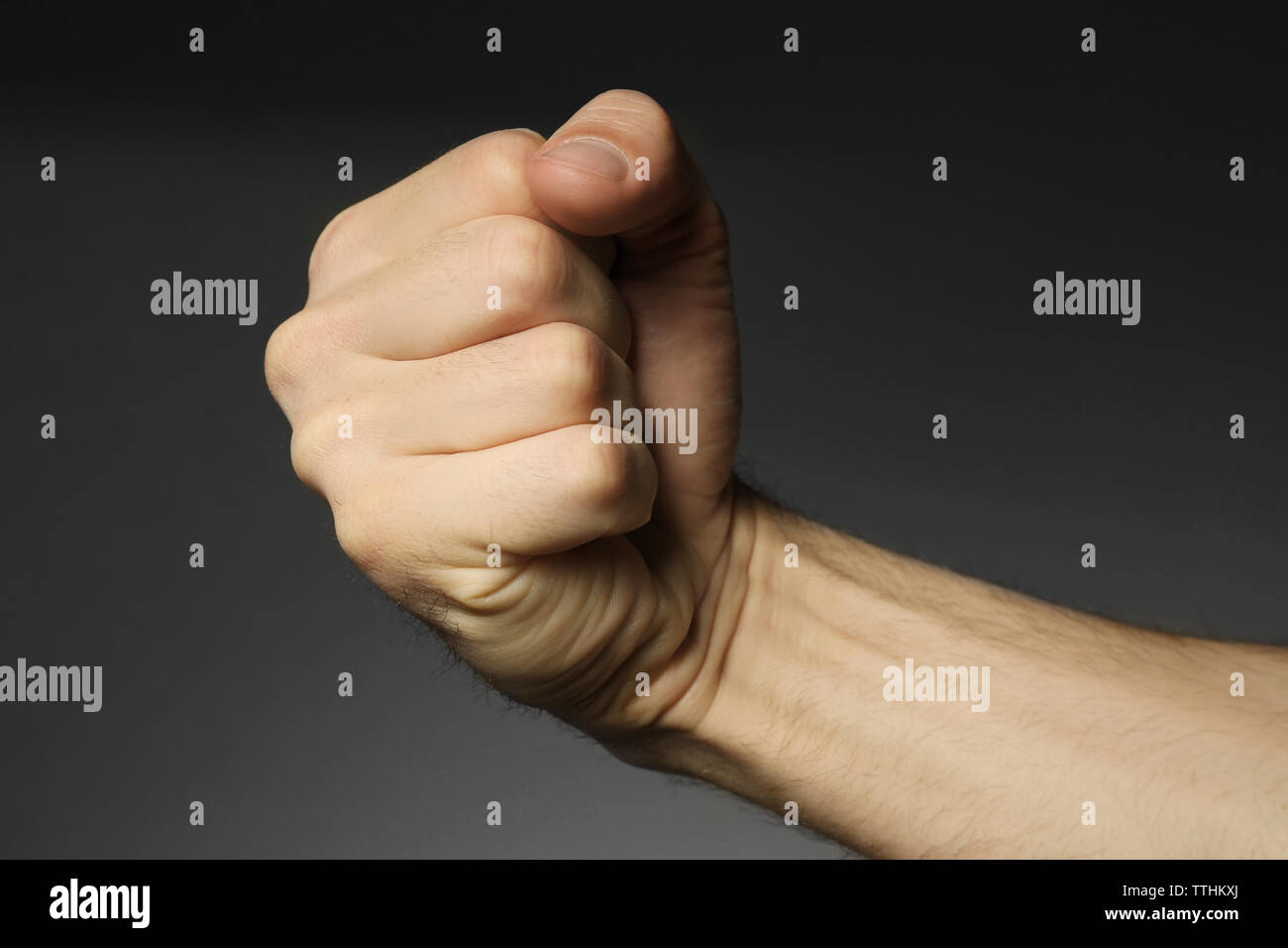 Male fist on grey background Stock Photo - Alamy