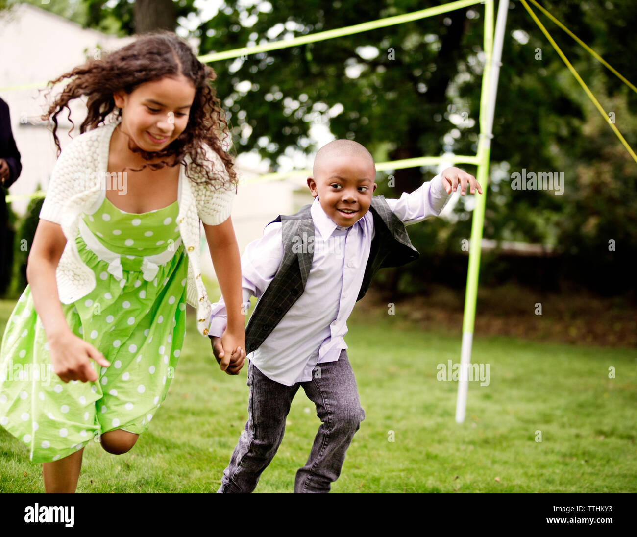 Happy siblings running in backyard Stock Photo - Alamy
