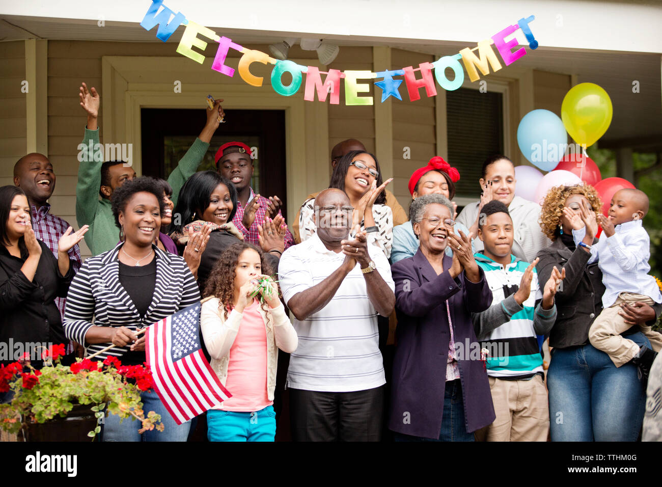 Happy family and friends welcoming while standing outside house Stock ...