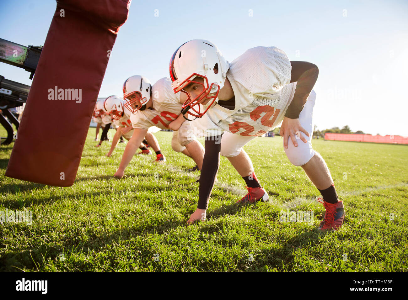 American football players bending by sled at field Stock Photo - Alamy