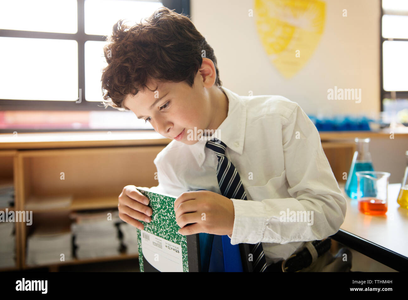 Schoolboy removing book from bag in laboratory Stock Photo - Alamy