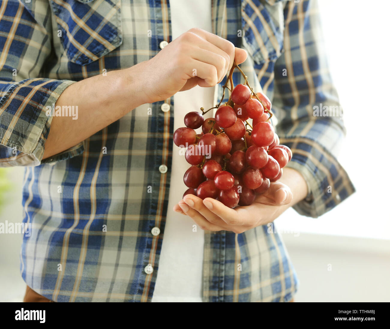 Man holding big bunch of grapes Stock Photo - Alamy