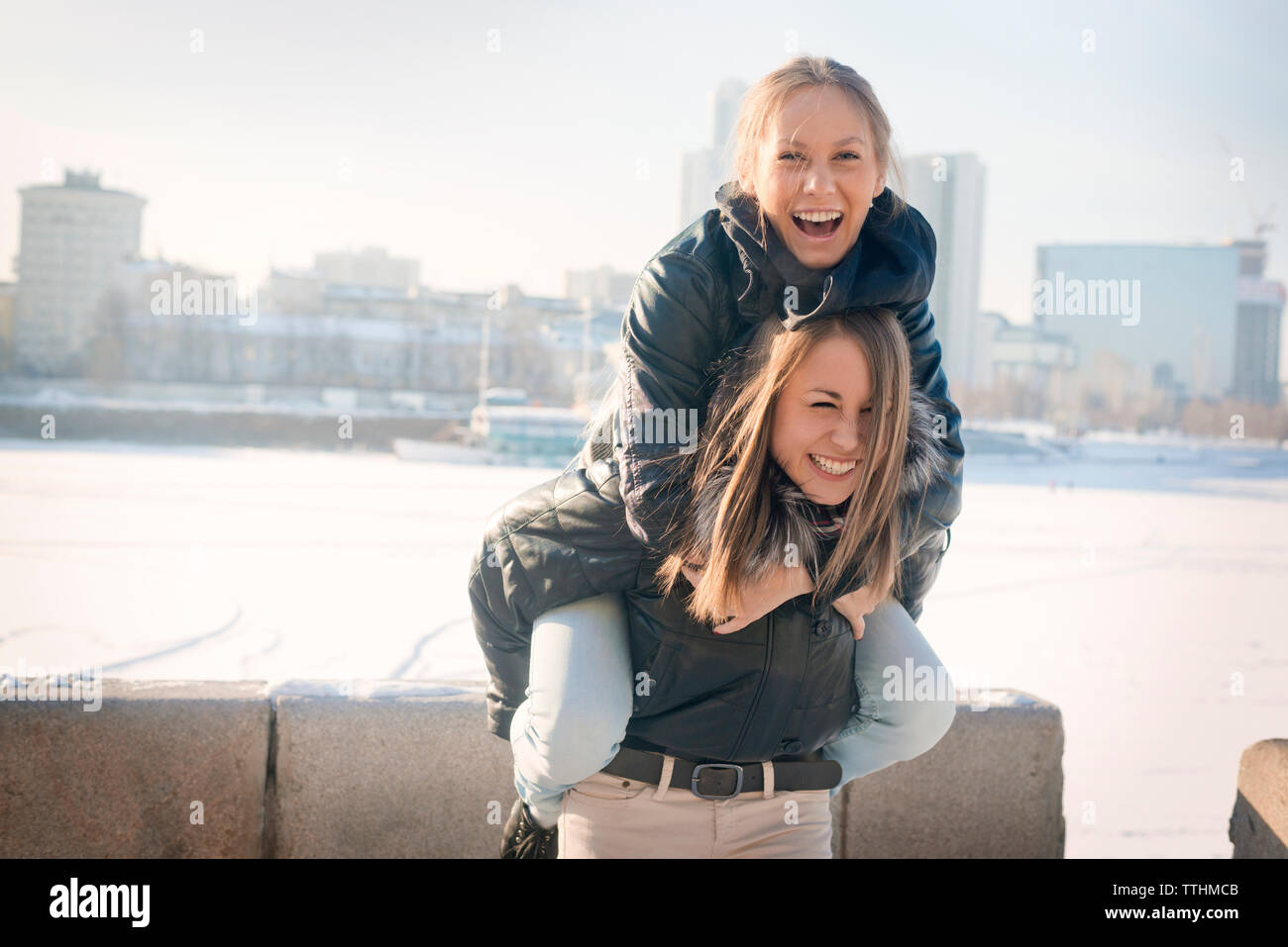 Portrait of cheerful woman giving piggyback to friend Stock Photo - Alamy