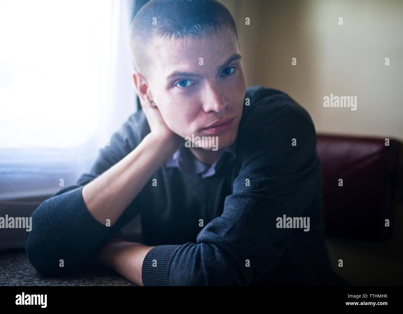 Portrait of man sitting by table in train Stock Photo - Alamy