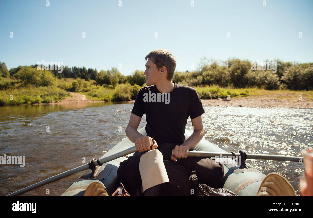 Man travelling on raft at river against sky Stock Photo - Alamy