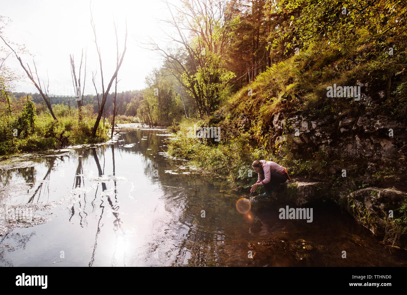 Side view of woman washing hands on river Stock Photo - Alamy