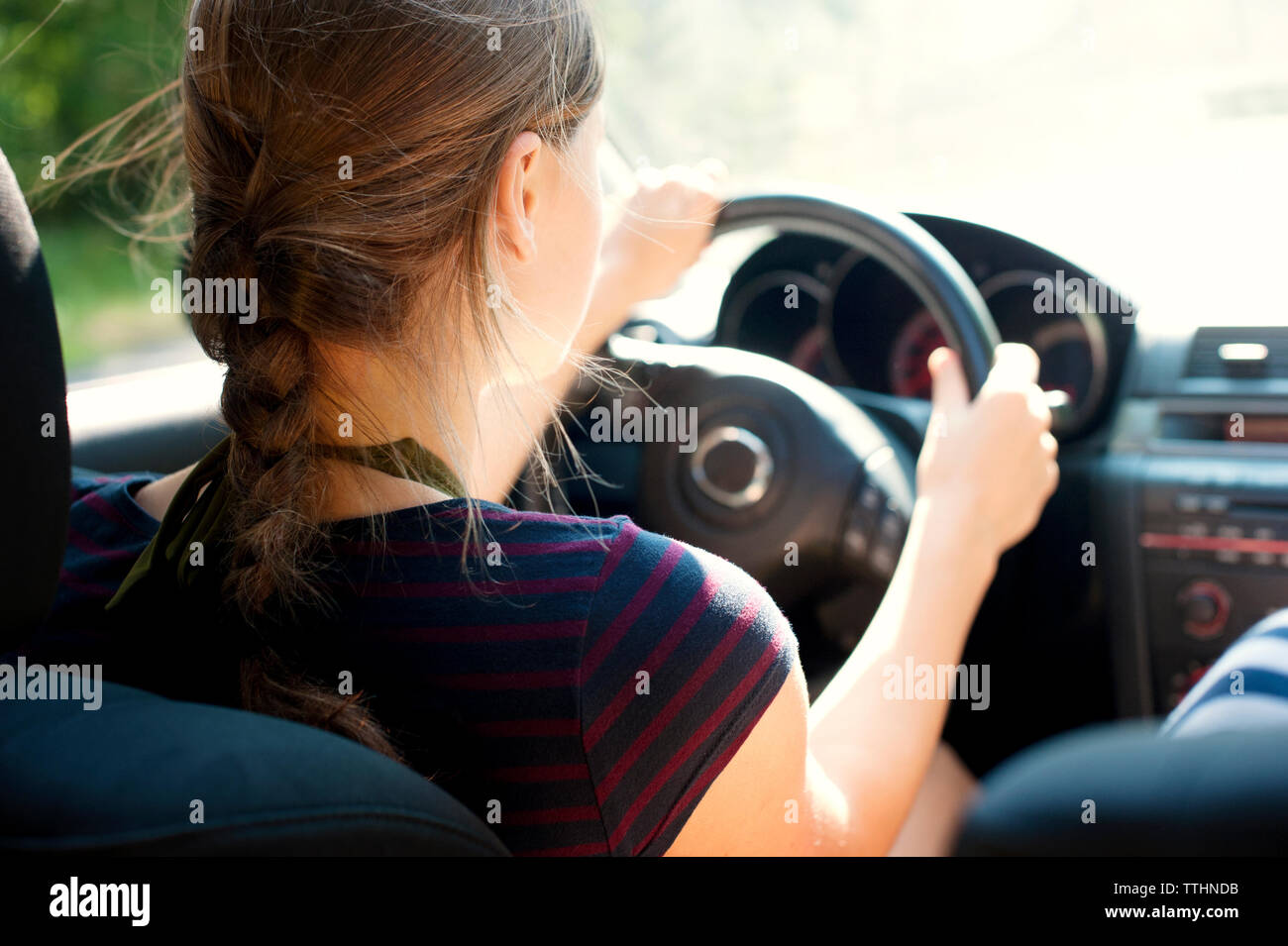 Rear view of teenage girl driving car Stock Photo - Alamy
