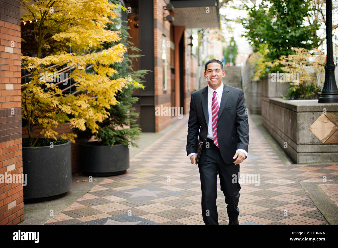 Portrait of smiling businessman walking outside building Stock Photo ...