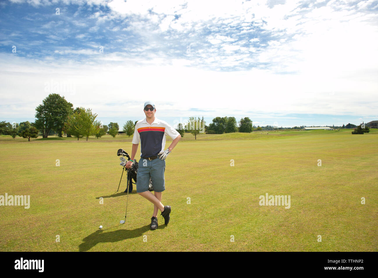 Happy man standing at golf course against sky Stock Photo - Alamy