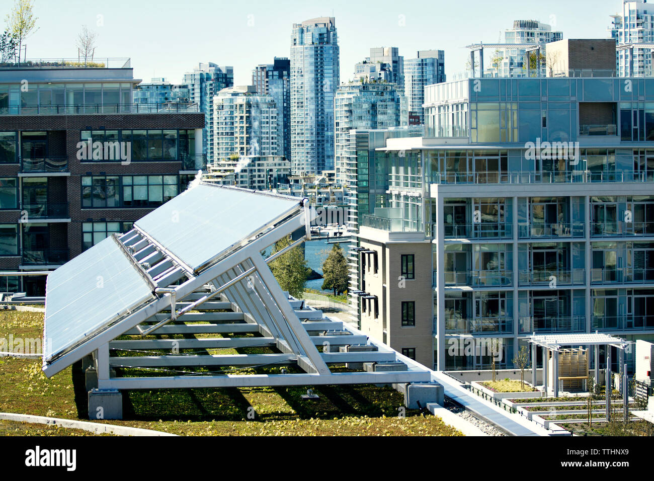 Solar panel on field by buildings in city Stock Photo - Alamy