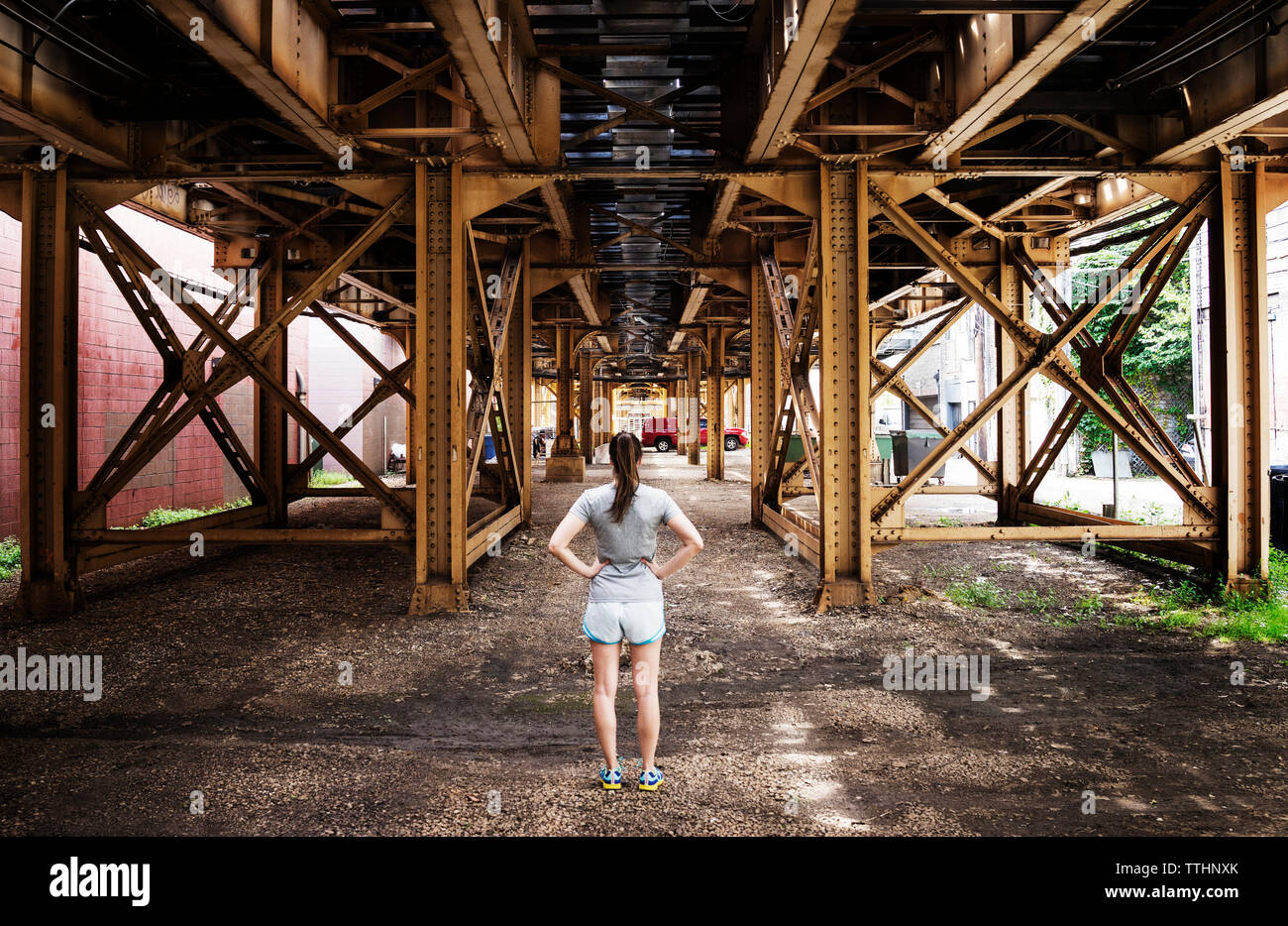 Rear view of woman standing below bridge Stock Photo - Alamy
