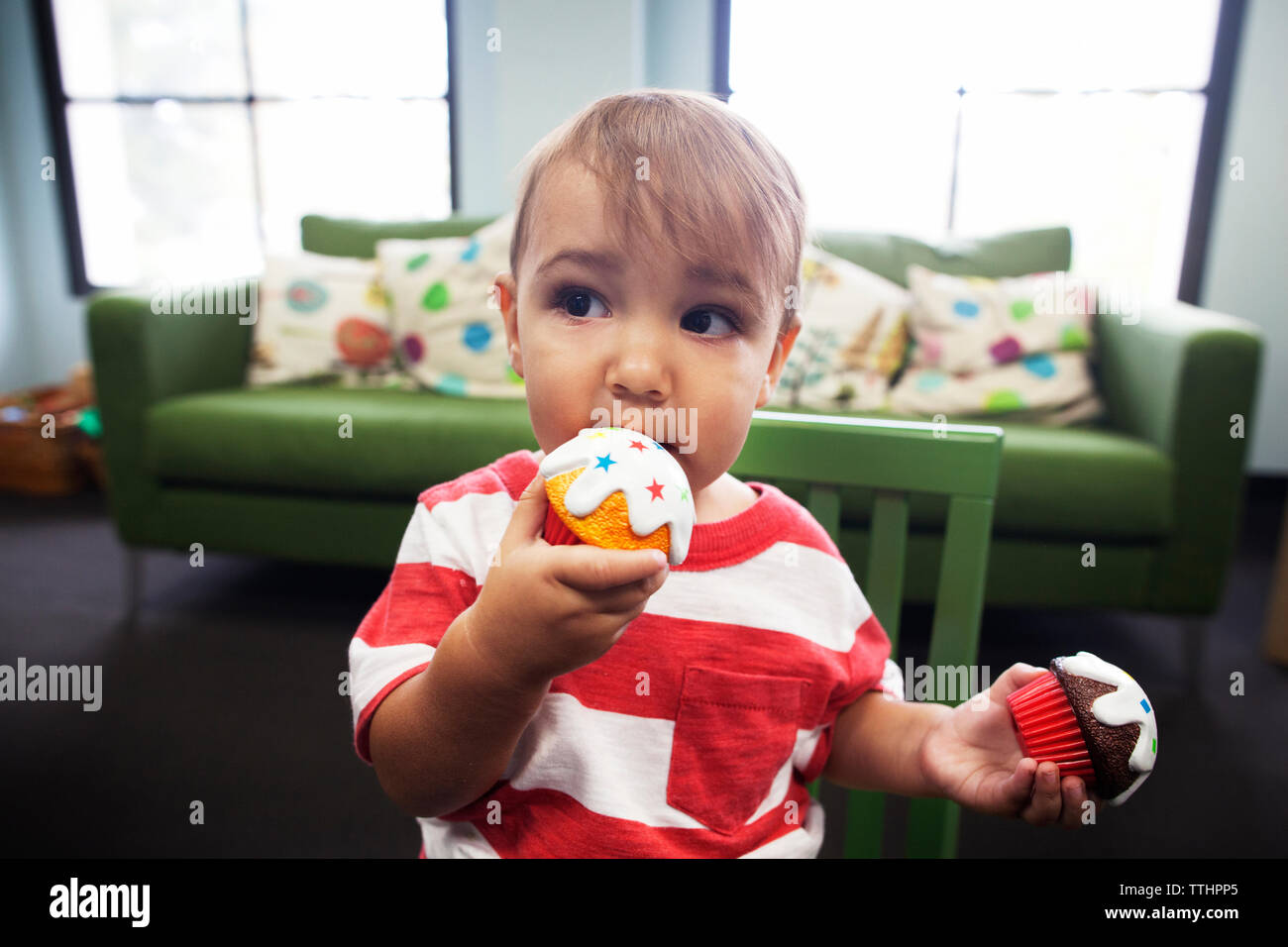 Boy eating artificial toy while looking away at preschool Stock Photo ...