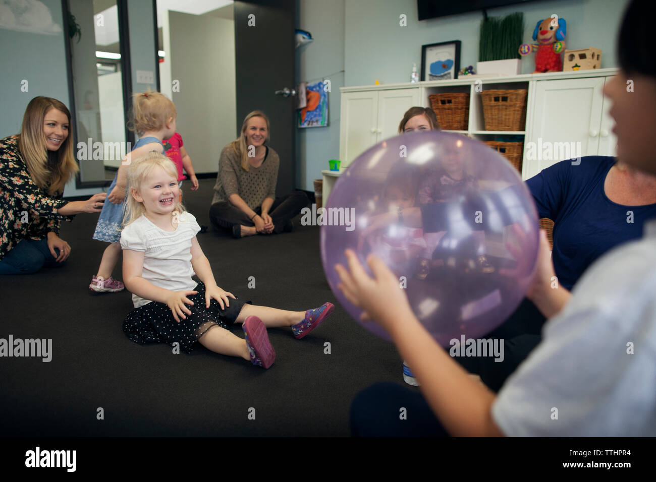 Playful children with teachers at preschool Stock Photo - Alamy