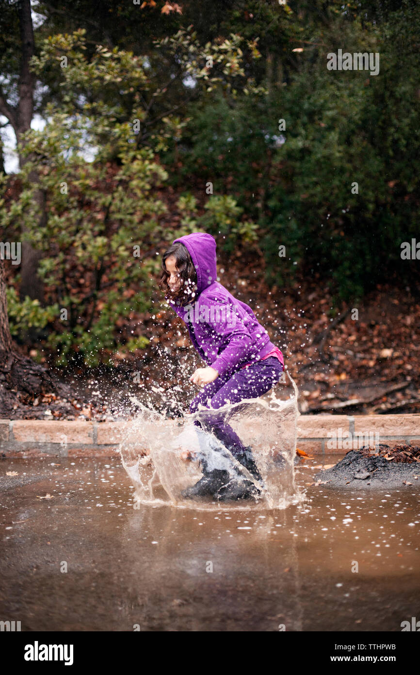 Girl playing in puddle at field Stock Photo - Alamy