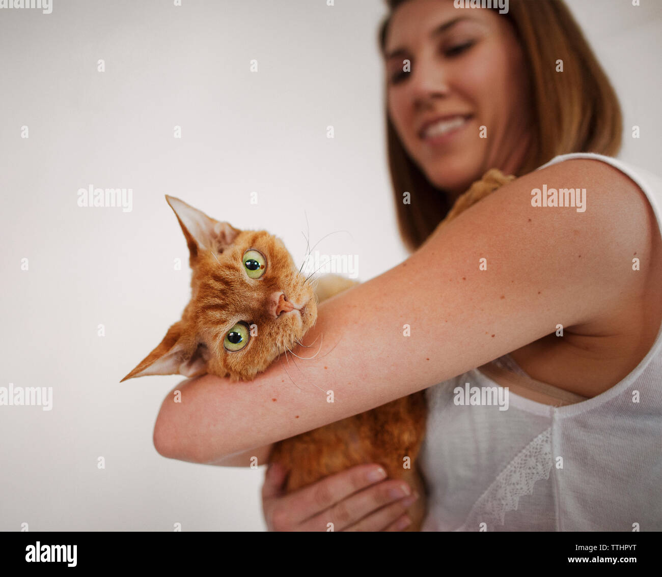Side view of woman carrying cat at home Stock Photo - Alamy