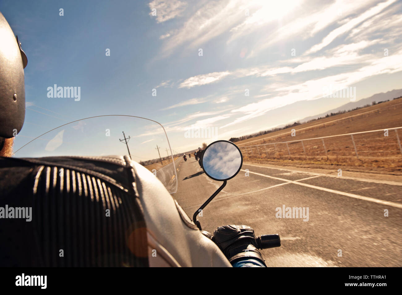 Cropped image of biker on road Stock Photo - Alamy