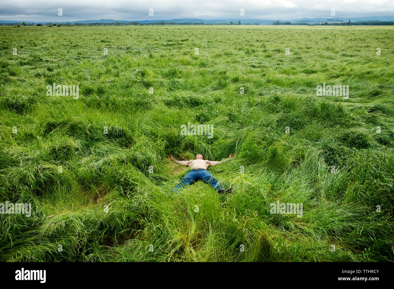 Man relaxing on grassy field Stock Photo - Alamy
