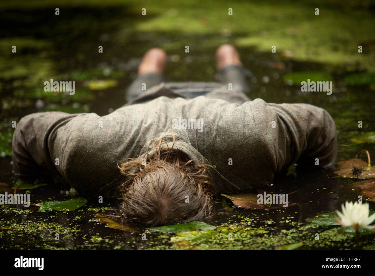 Man lying on swamp Stock Photo - Alamy