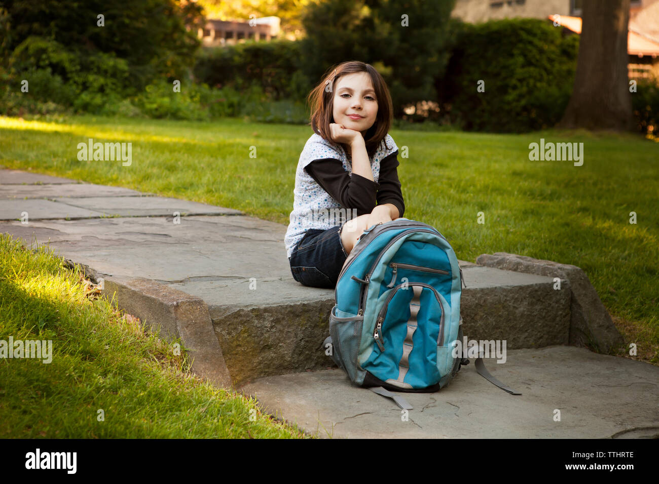 Portrait of girl sitting on steps in yard Stock Photo - Alamy