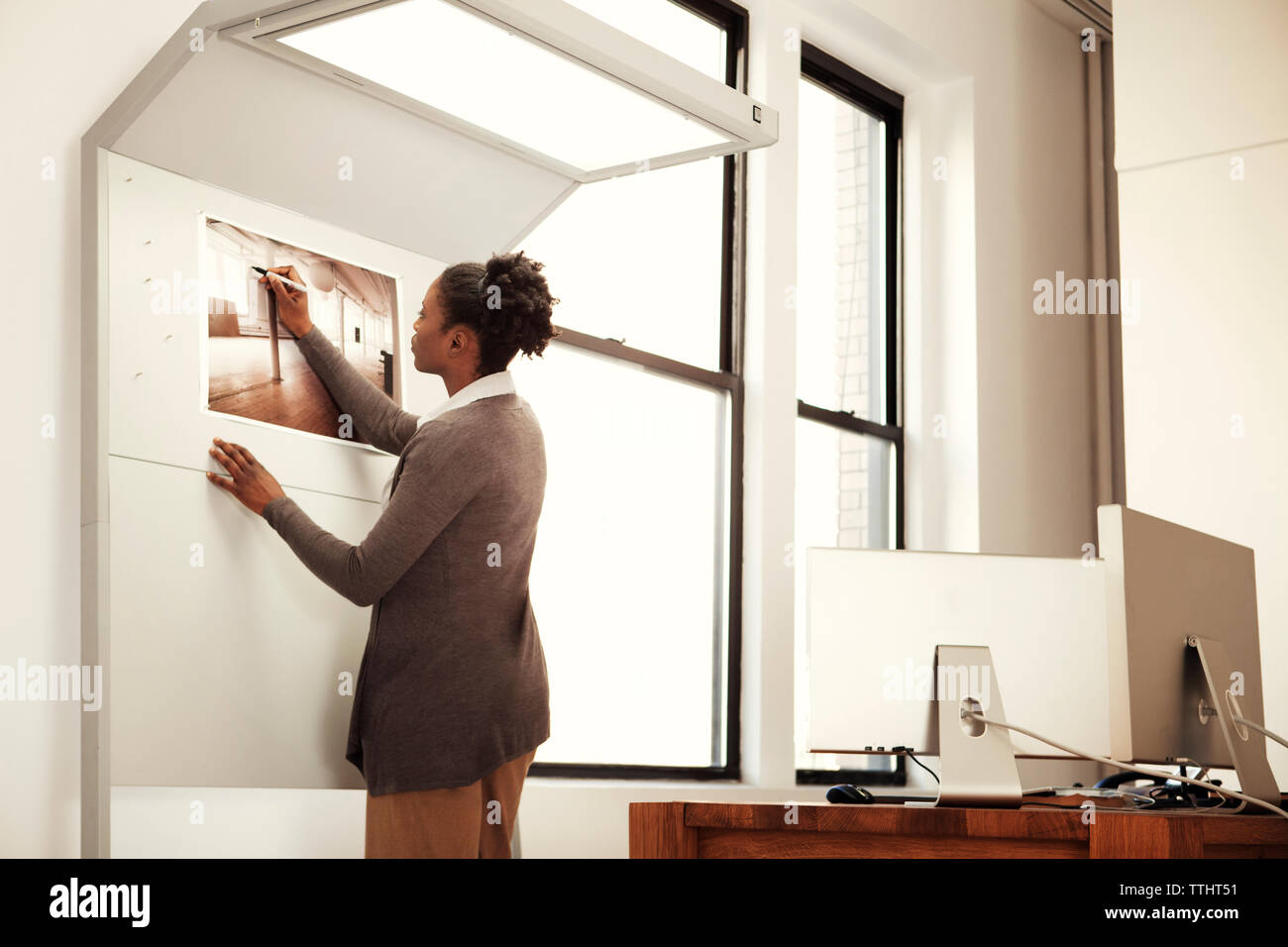 Woman writing on chart while standing in office Stock Photo - Alamy