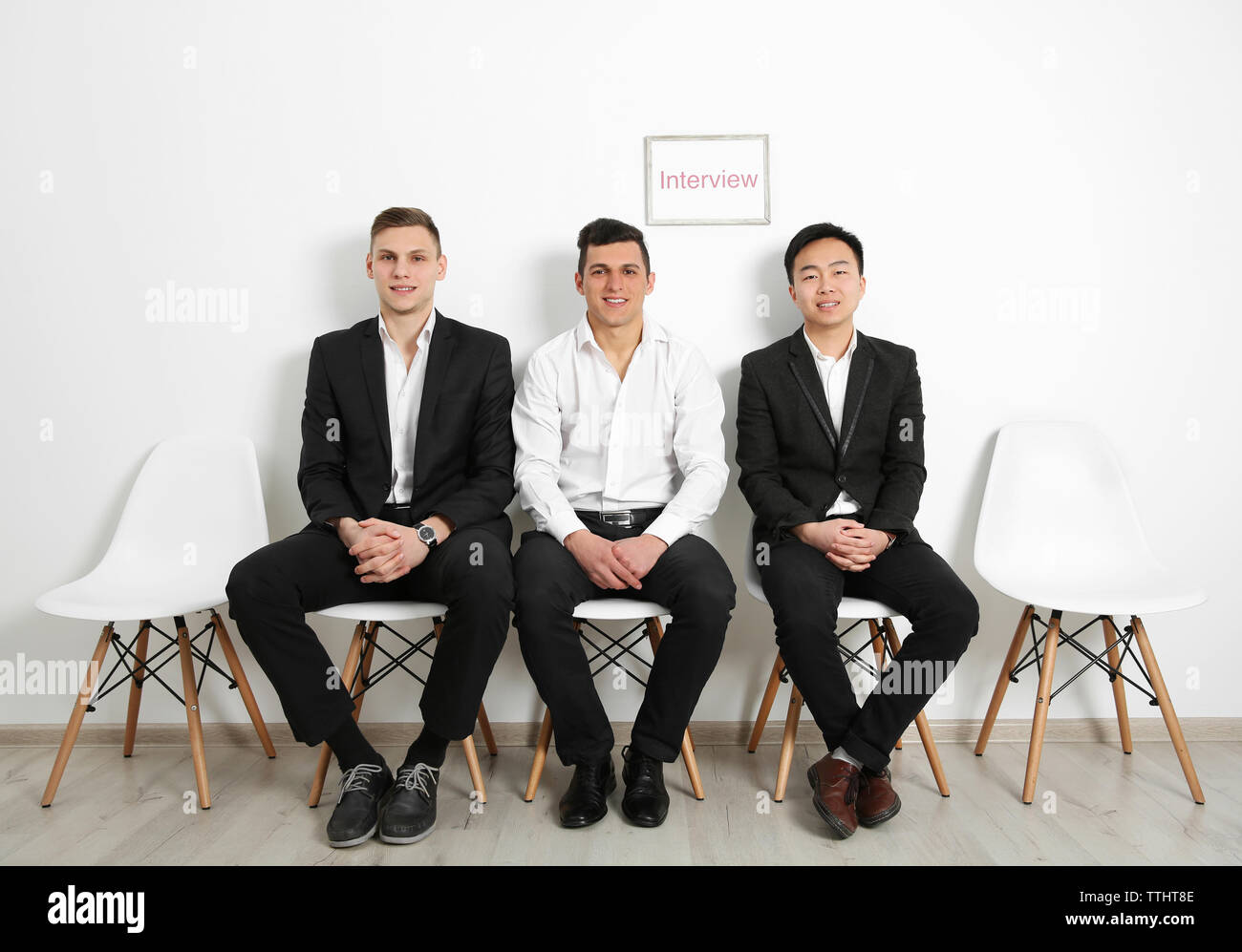 Three men waiting for interview indoors Stock Photo - Alamy