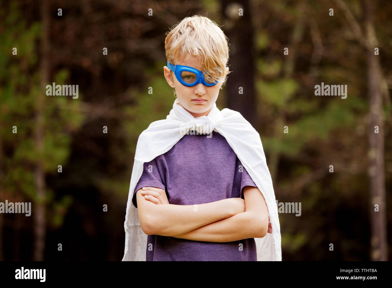 Portrait of boy wearing cape standing with arms crossed Stock Photo - Alamy