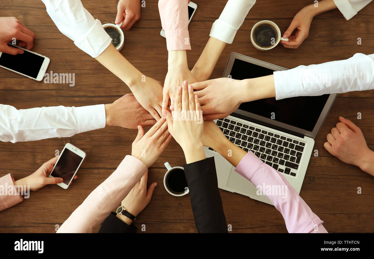 Teamwork concept. Business people hands over wooden table, top view ...