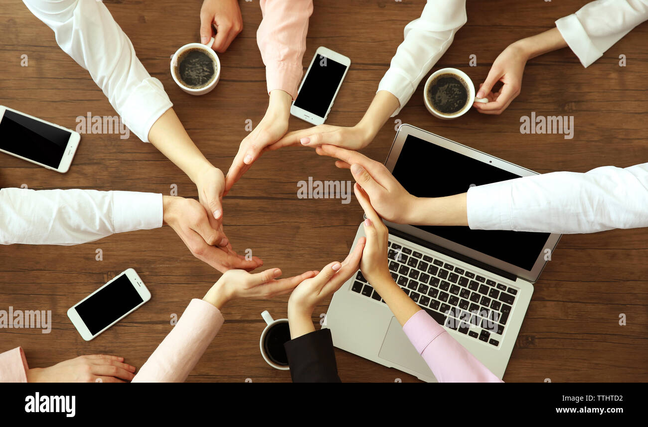 Teamwork concept. Business people hands over wooden table, top view ...